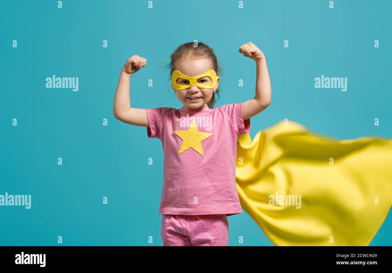 Little child playing superhero. Kid on the background of bright blue ...