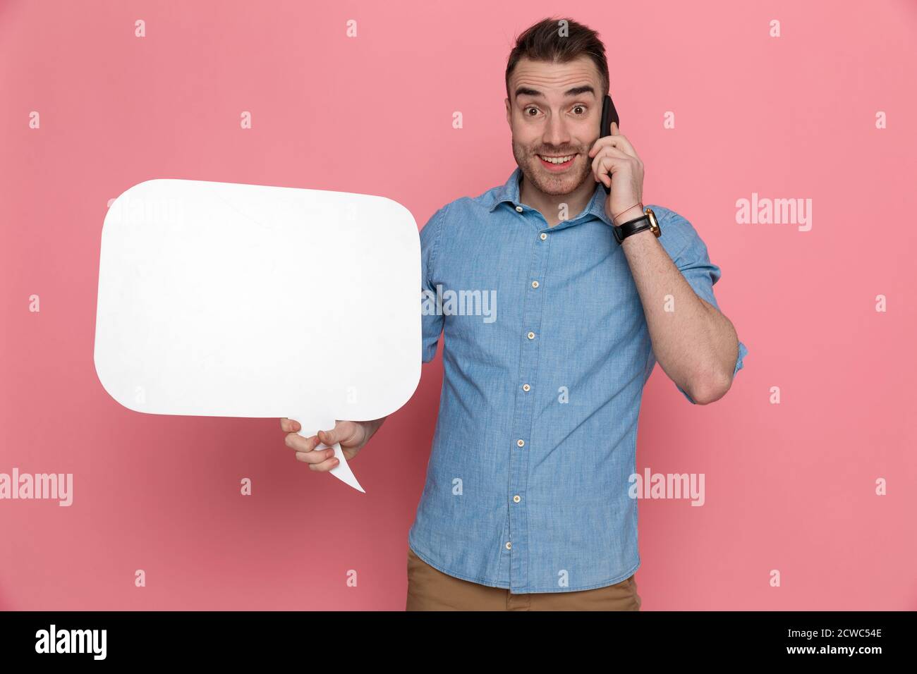 casual man talking on the phone, smiling and holding a speech bubble on ...