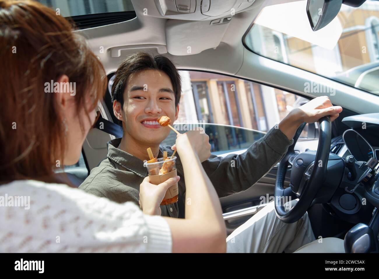 The young couple to eat in the car Stock Photo - Alamy