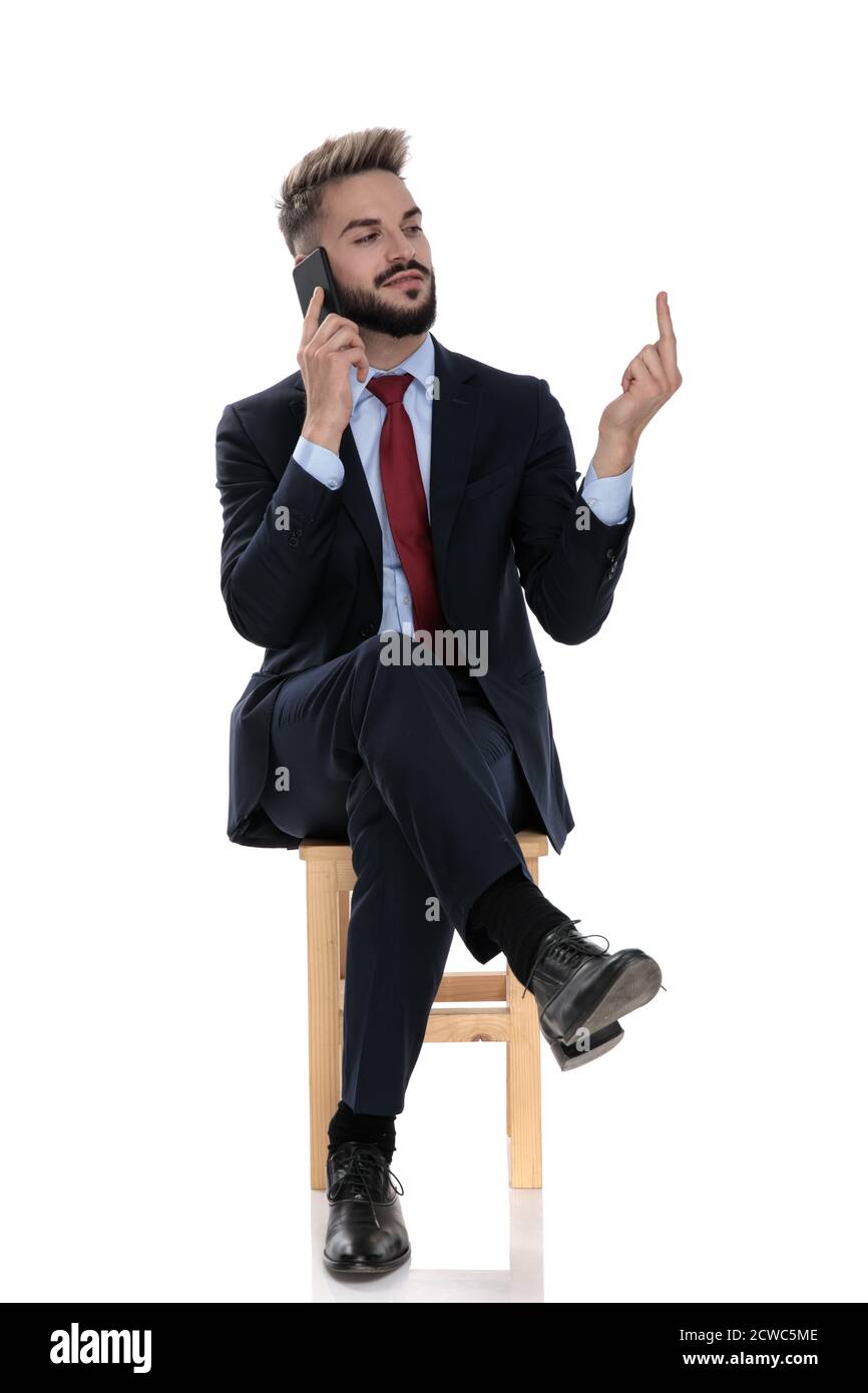 young businessman talking on the phone and showing middle finger to ...