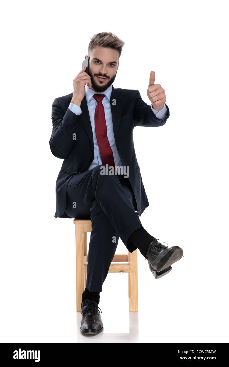 happy young businessman talking on the phone and making thumbs up sign ...