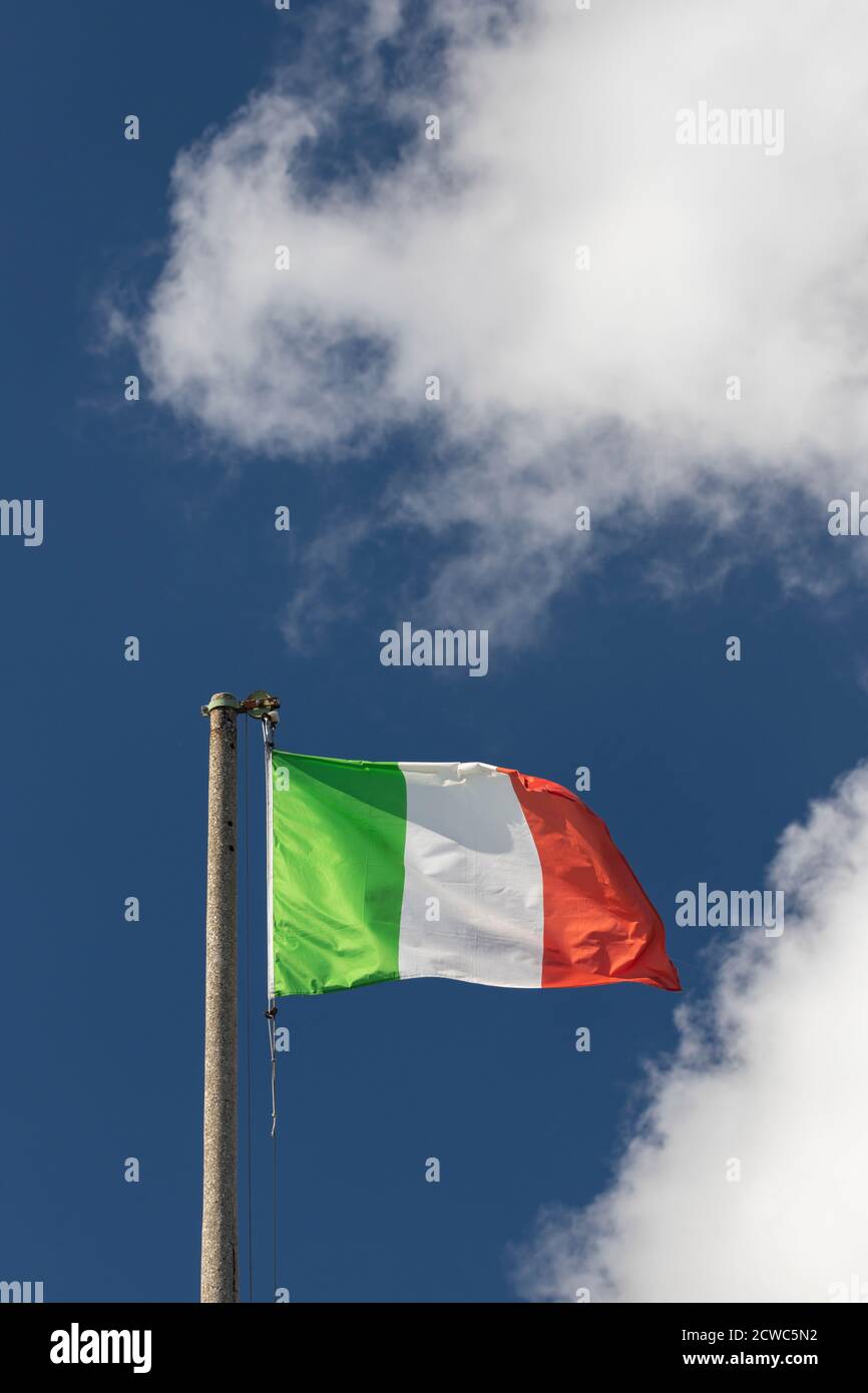 Italian flag blowing in the wind in the blue sky Stock Photo - Alamy