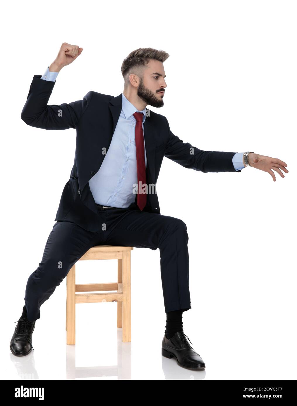 angry young businessman punching and chasing, sitting isolated on white ...