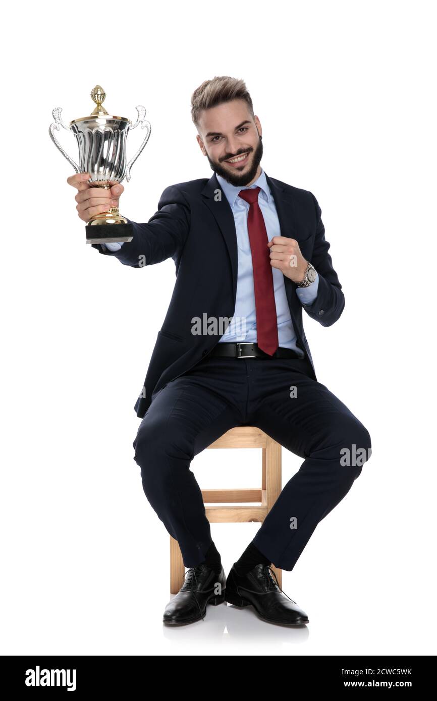 happy young businessman holding and presenting trophy and smiling ...