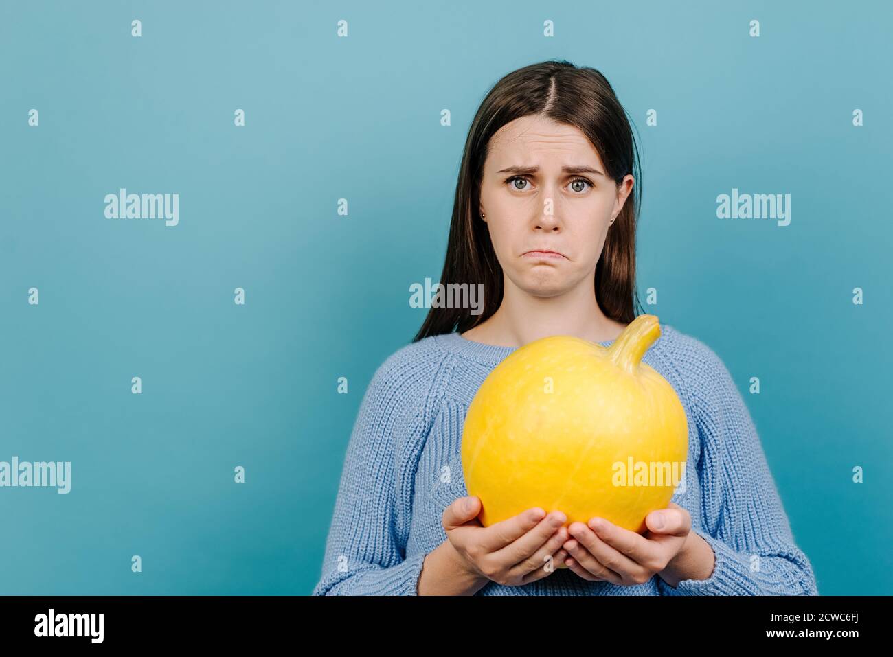 Tired unhappy young woman feels disgust, holds small ripe yellow ...