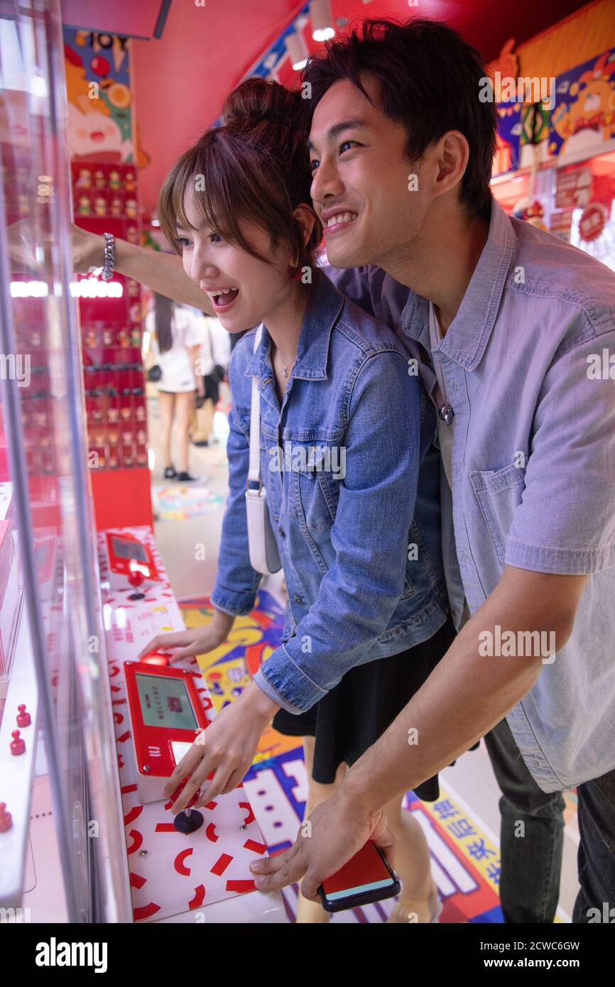 Happy couples playing catch a doll Stock Photo - Alamy
