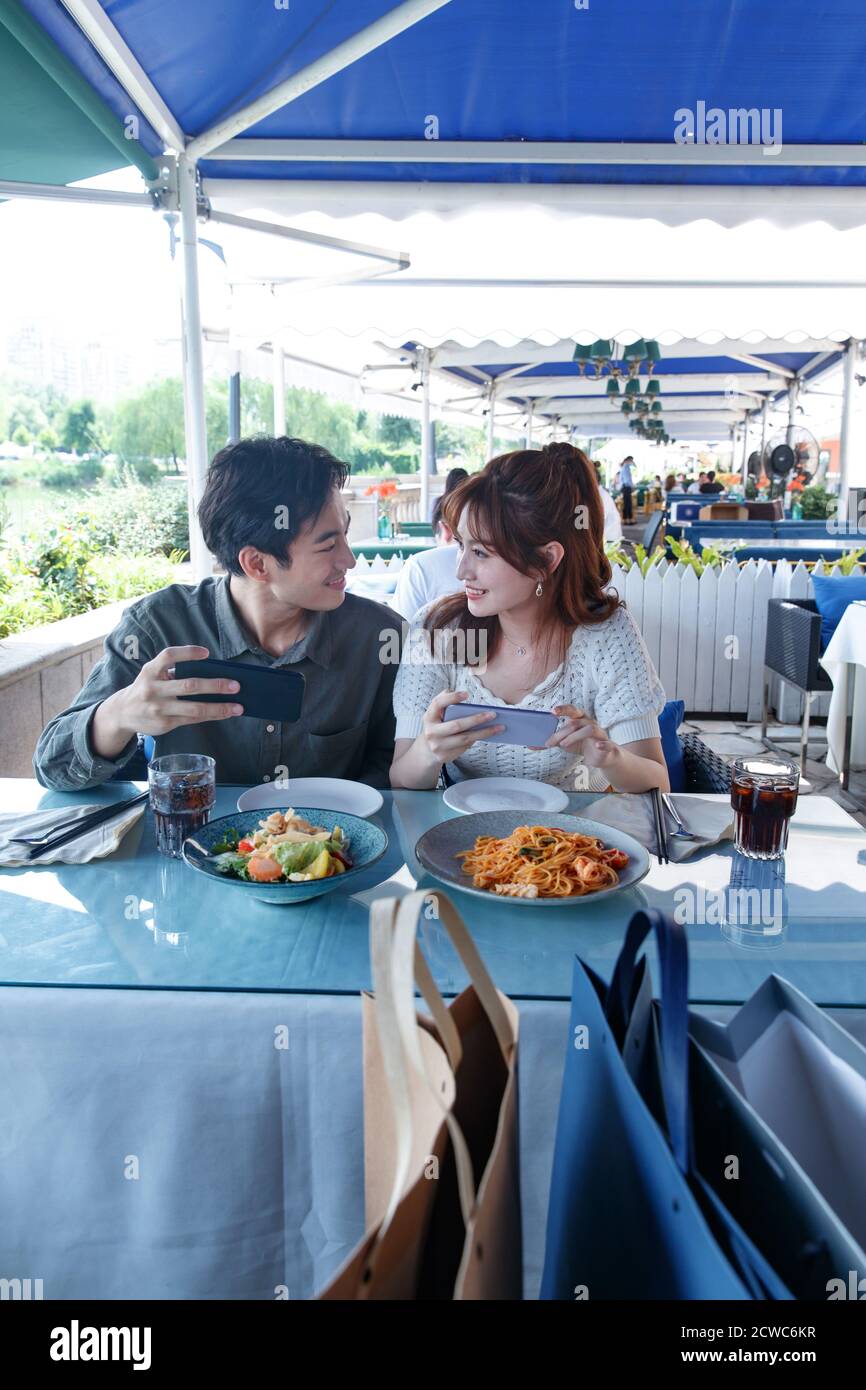 Young couples in the dining room with mobile phones Stock Photo - Alamy