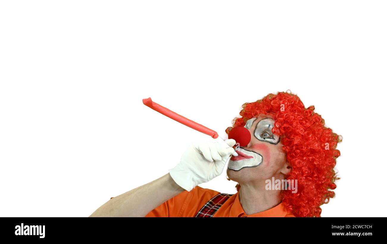Funny clown blowing a pipe on a celebration on white background Stock ...