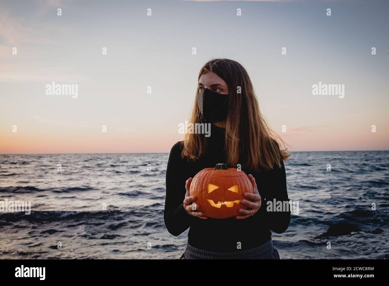 Woman wearing protective mask holding jack o lantern pumpkin Stock ...