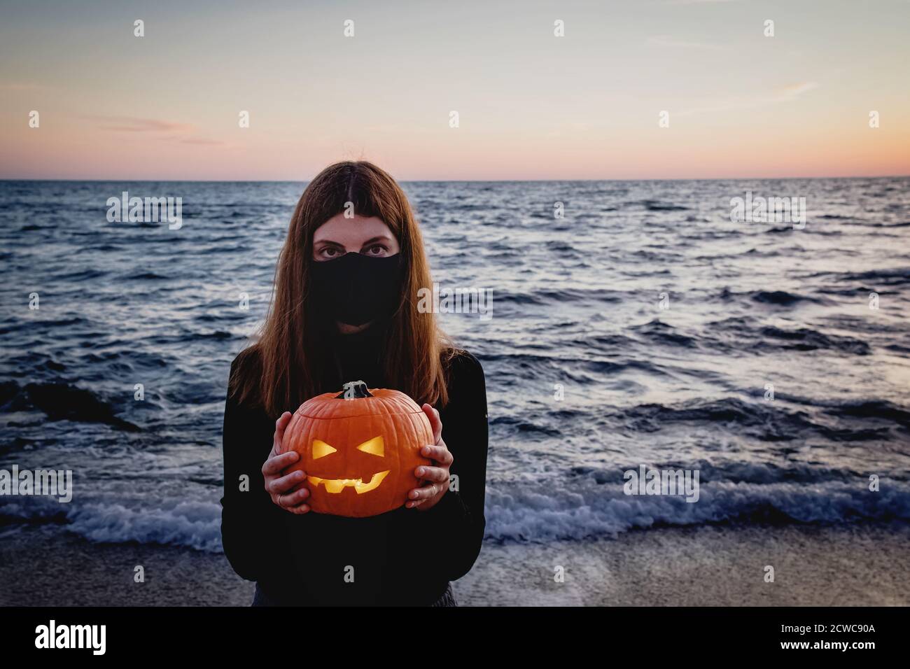 Woman wearing protective mask holding jack o lantern pumpkin Stock ...