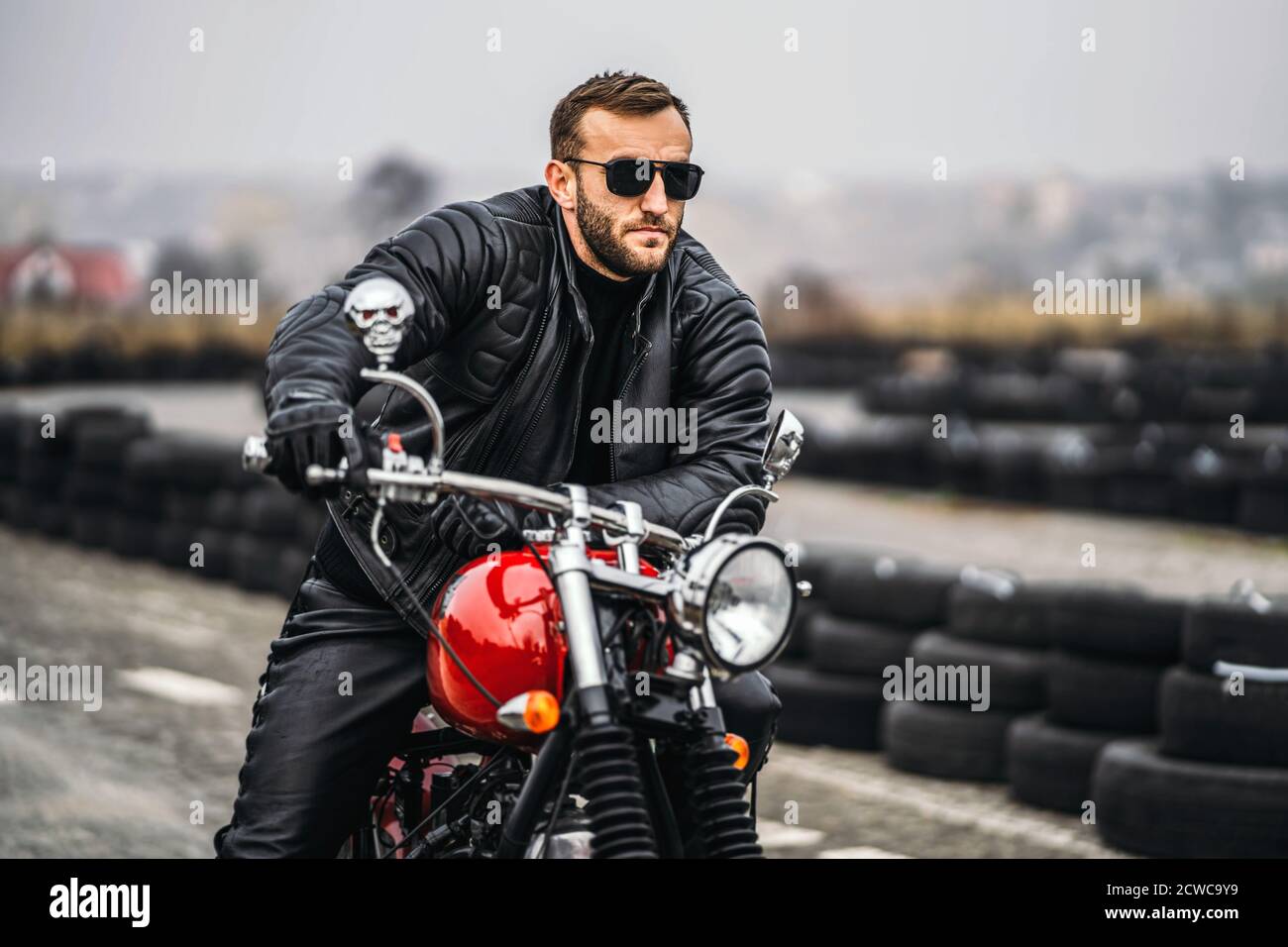 Bearded man in sunglasses and leather jacket looking at the camera ...