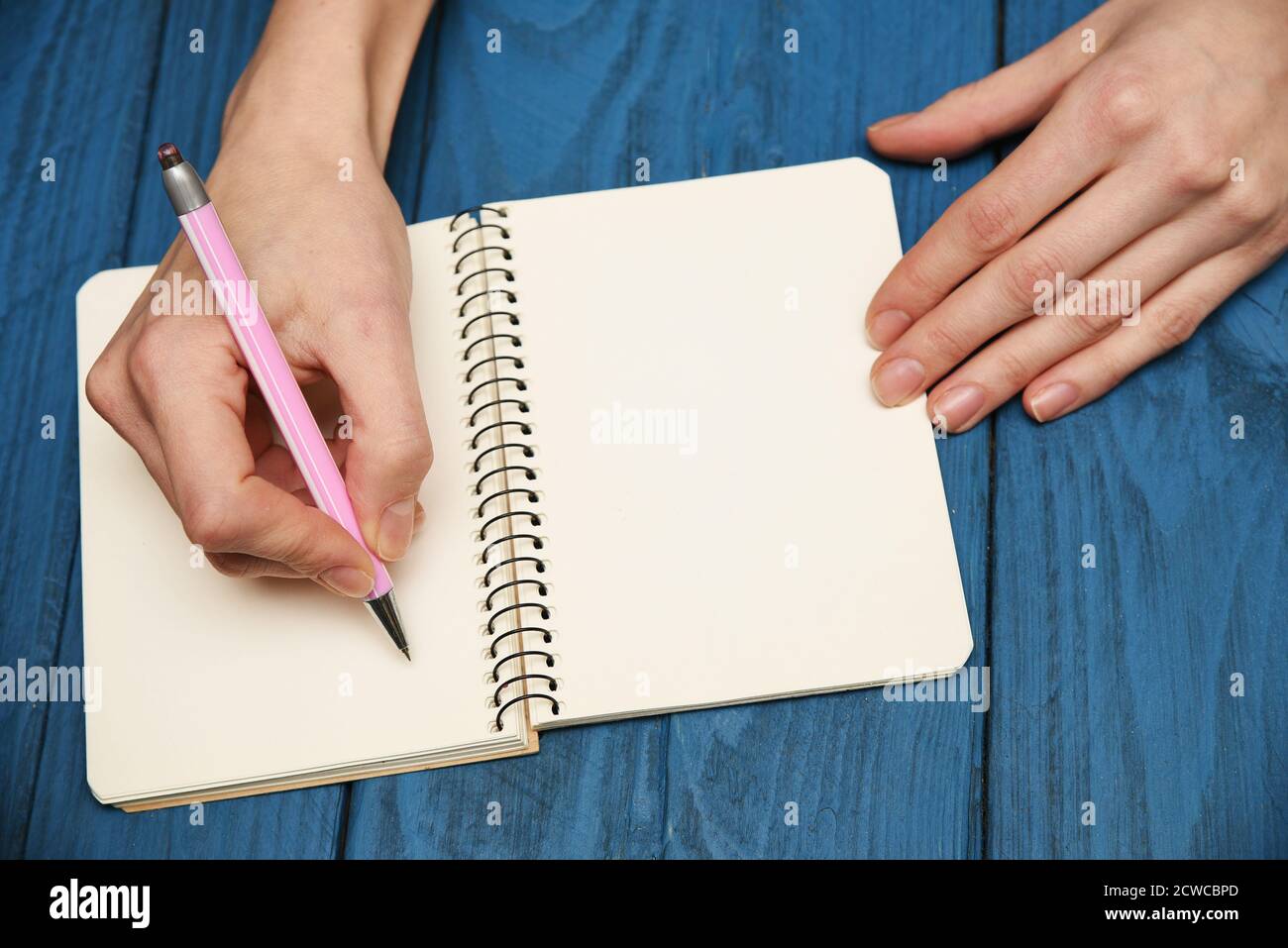 Girl writing in notebook, over head view Stock Photo - Alamy