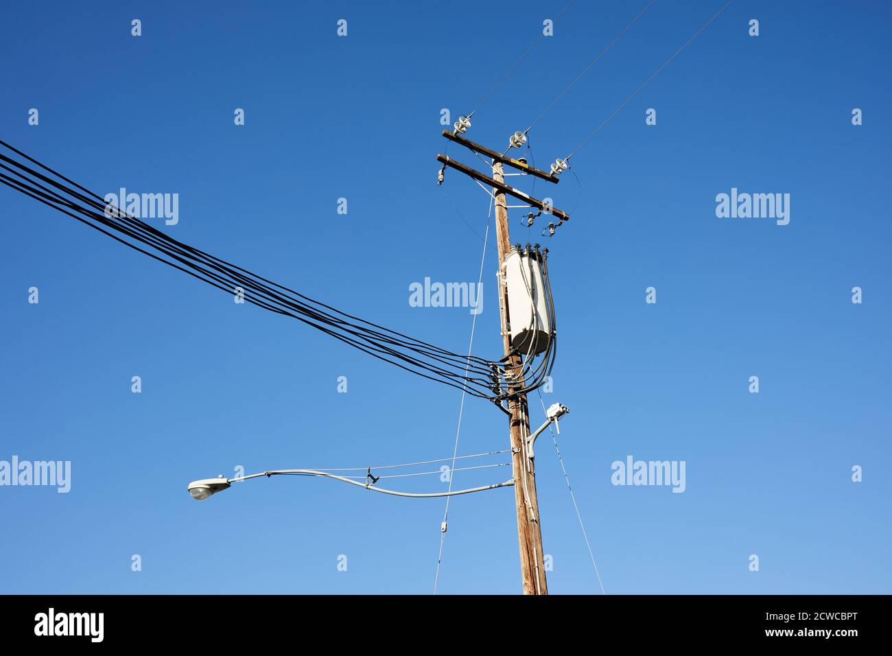 Utility pole/lamp post and wires against a blue sky Stock Photo - Alamy