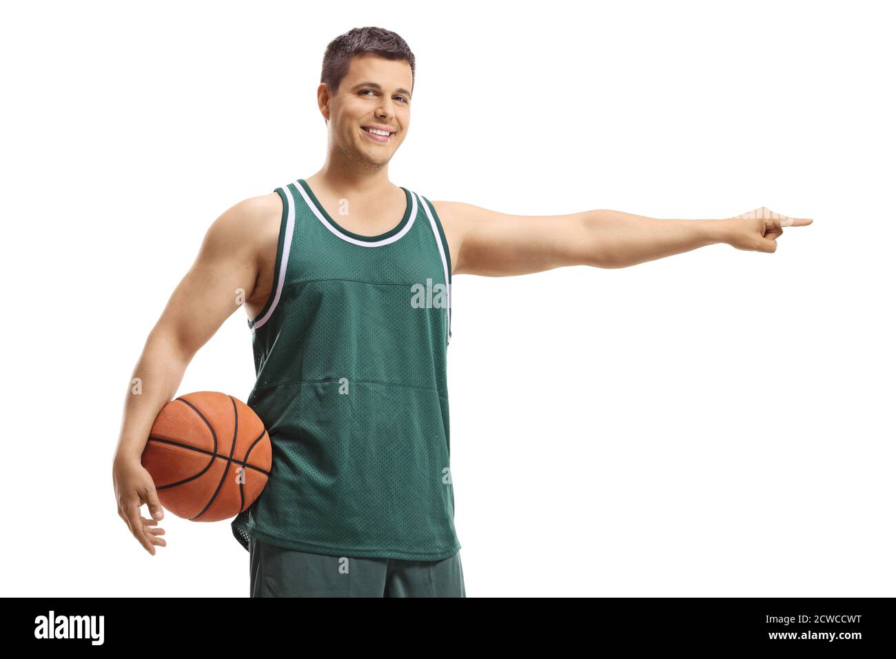 Basketball player in a jersey holding a ball and pointing to one side ...