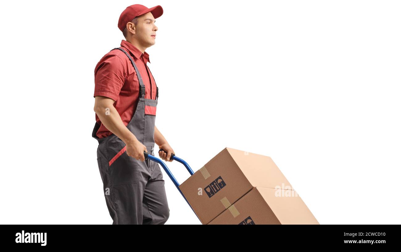 Worker in a uniform pushing boxes on a hand truck isolated on white ...