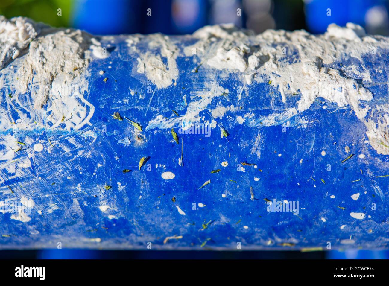 Dirty blue painted metal pipes stained with pieces of cement. Peeling ...