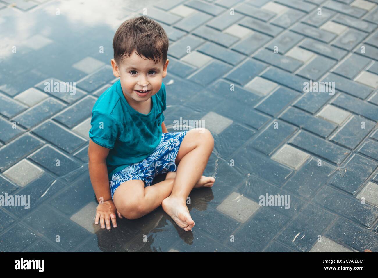 Smiling caucasian boy looking up at camera and smile while play in ...