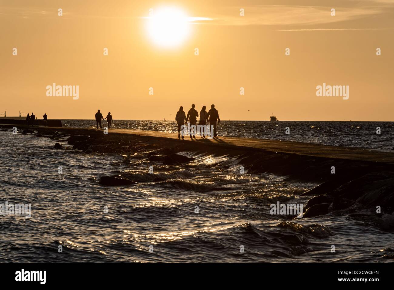 The silhouette of the people walking on the pier. Evening pastime Stock ...