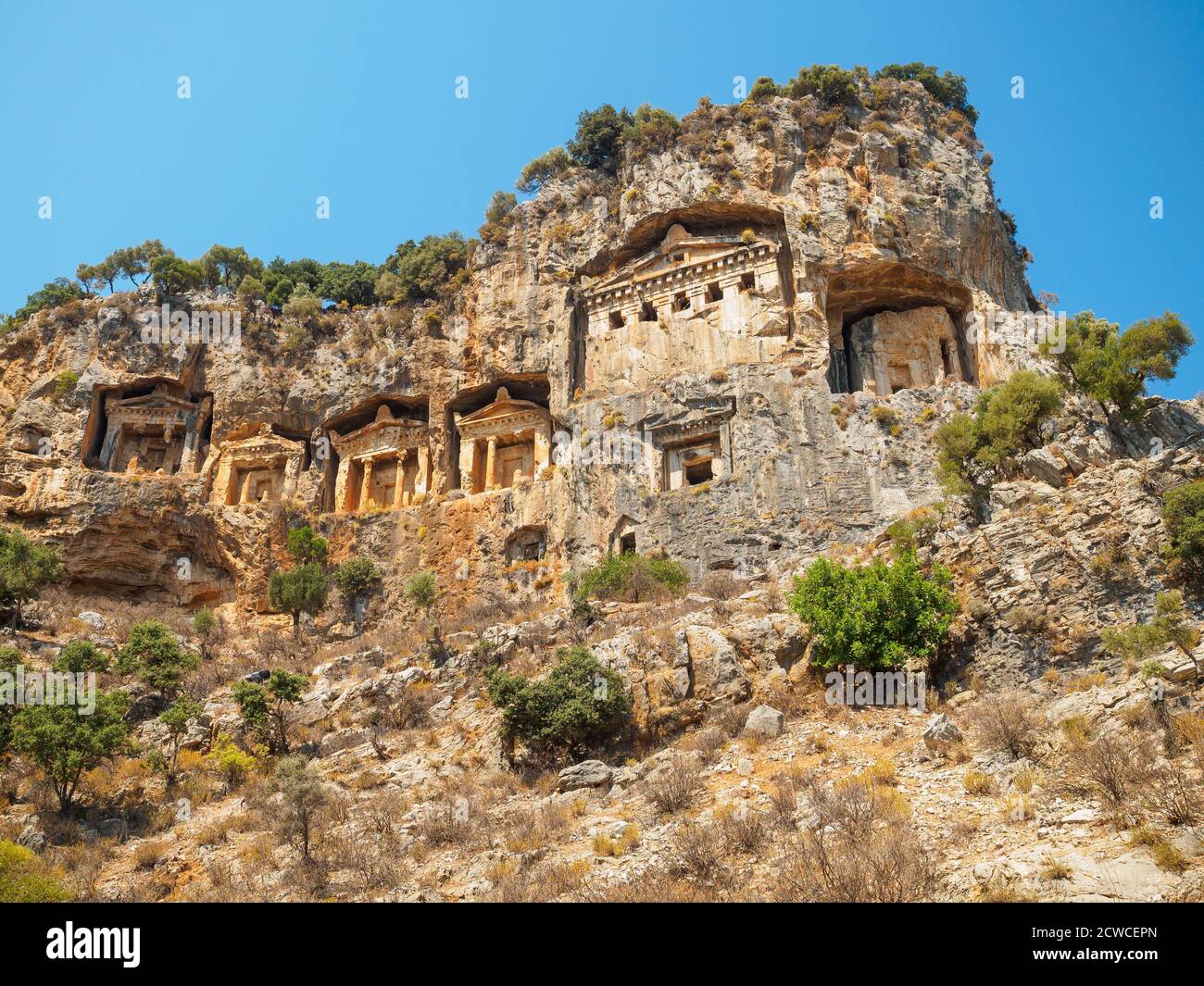 Ancient rock tombs of the Lycian Kings cut into the rock face above ...