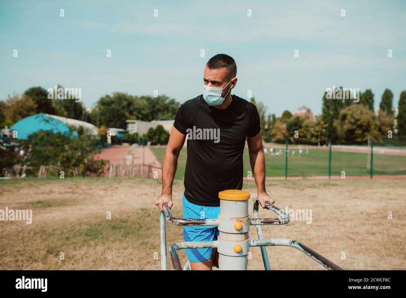 Handsome young male caucasian athlete with face mask trains on arm and ...
