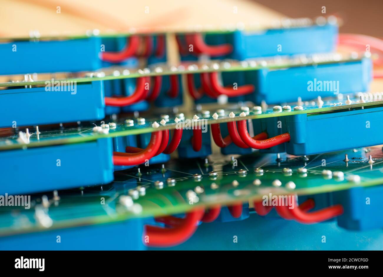 Close-up of a large green microcircuit with red HI-voltage wires and ...