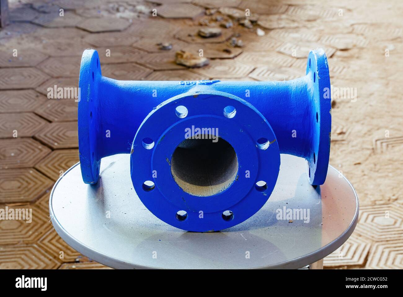 Cast metal pipe T shape connection with flange on gray table Stock ...