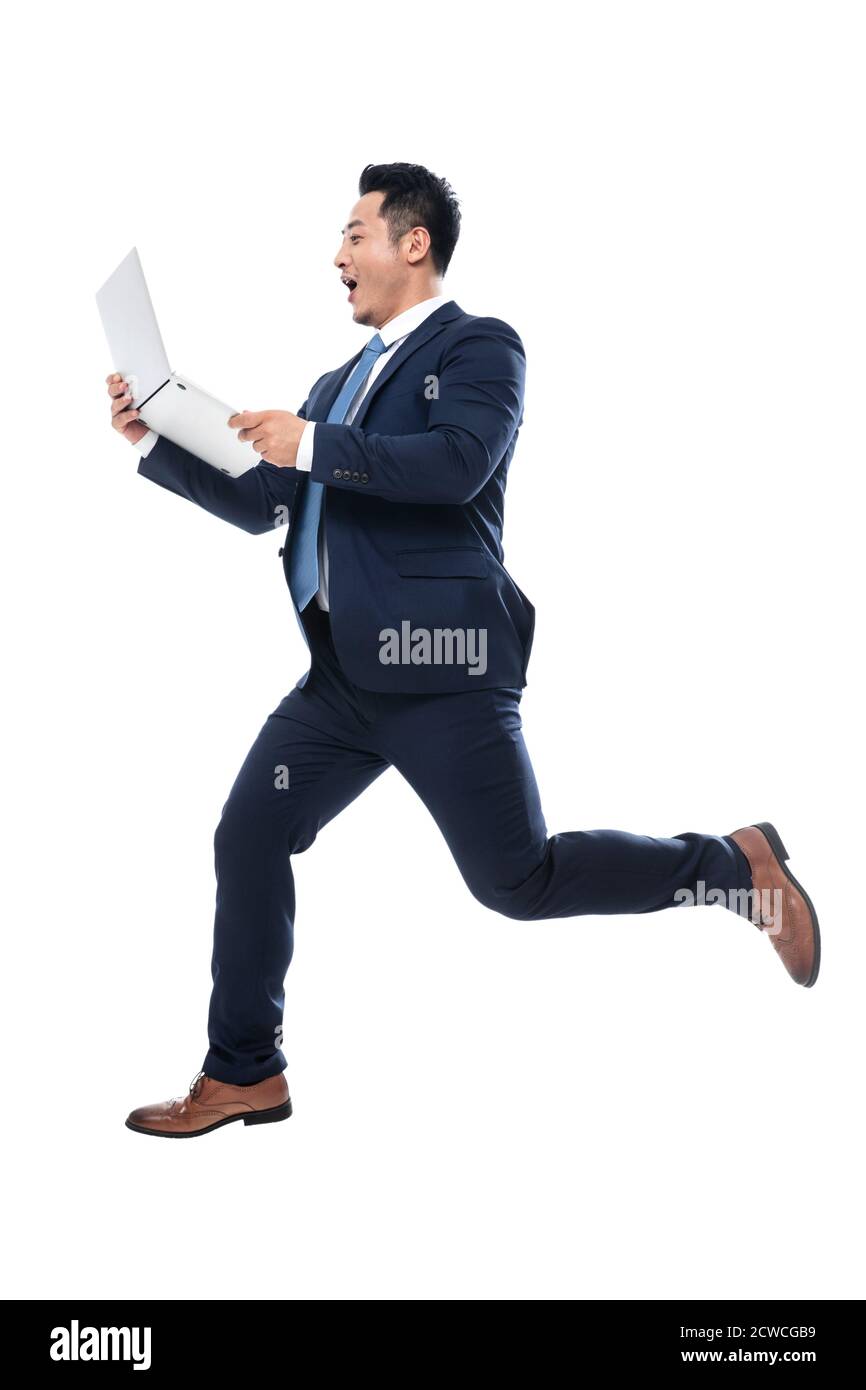 Carrying a laptop exciting business man Stock Photo - Alamy