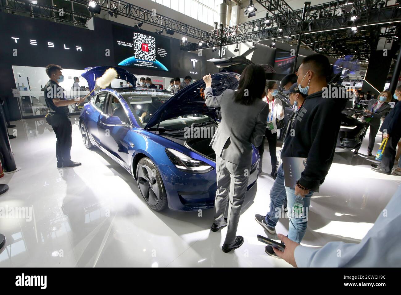 Beijing, China. 29th Sep, 2020. Chinese check out Tesla's Model 3 (L ...