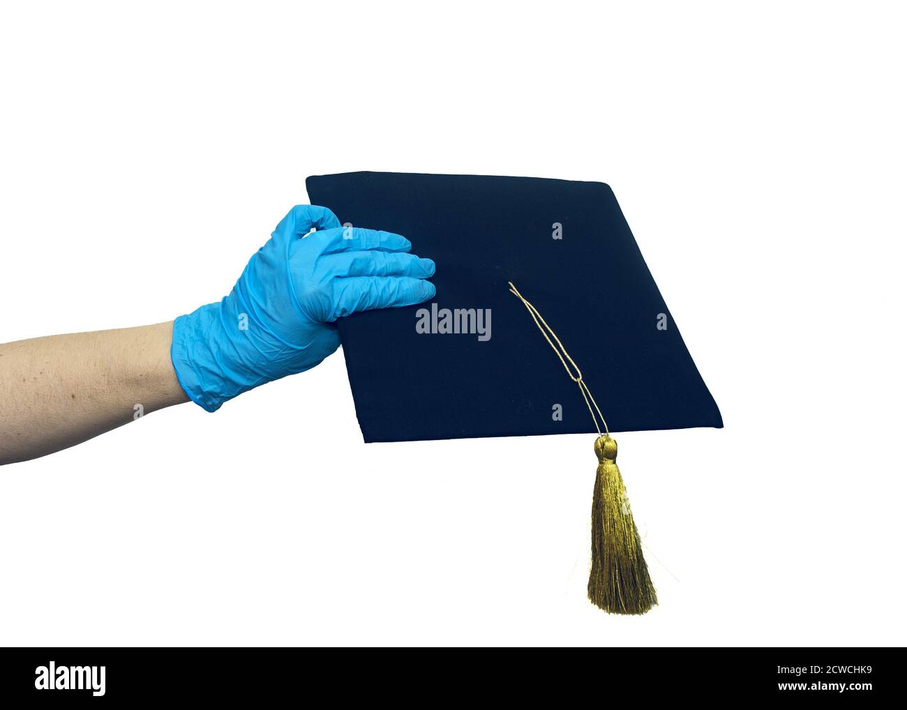 Hand in a blue nitrile surgical gloves holding a graduation cap on ...