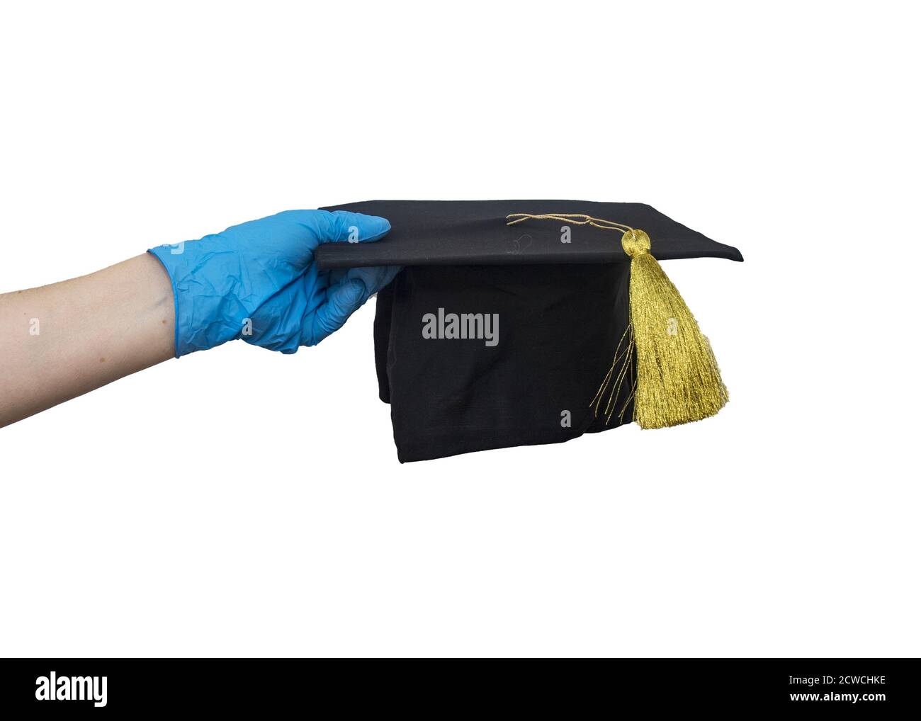 Hand in a blue nitrile surgical gloves holding a graduation cap on ...