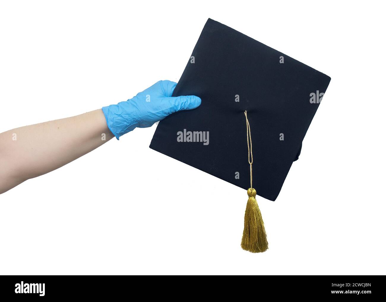 Hand in a blue nitrile surgical gloves holding a graduation cap on ...