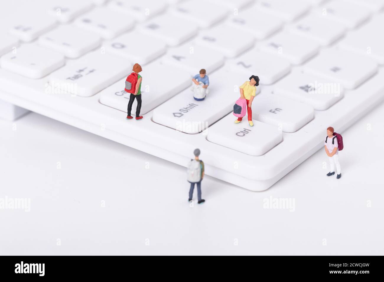 Closeup of a keyboard with miniature figurines of students around it ...