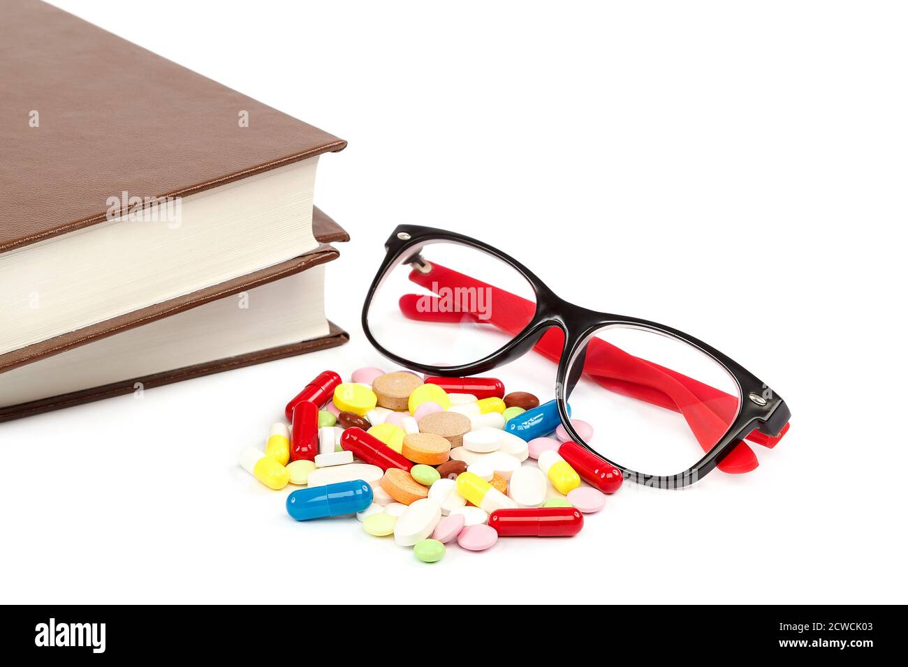 Stack of books and pills, capsules isolated on white background ...