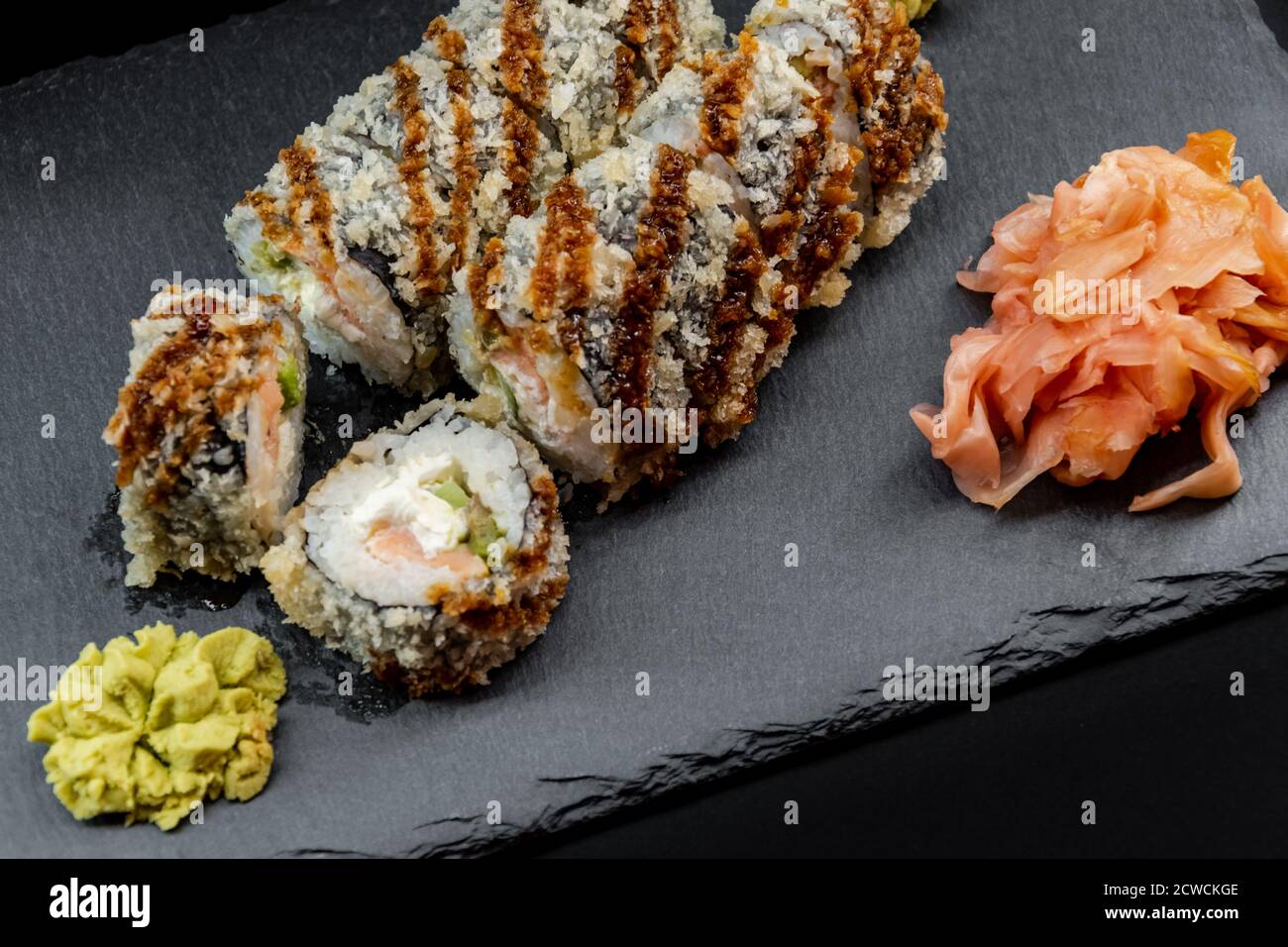 Served warm sushi with ginger and wasabi on a black stone plate Stock ...
