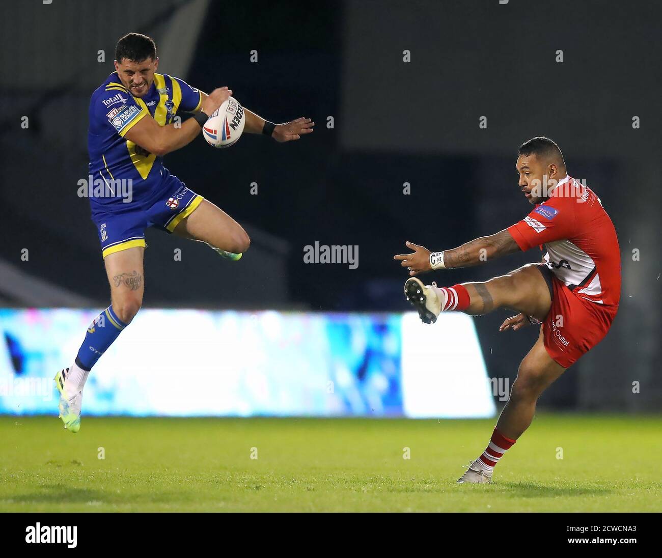 Warrington Wolves' Declan Patton (left) blocks the drop goal of Salford ...
