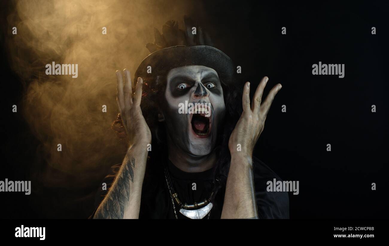 Creepy man with skeleton makeup in top-hat. Guy turning his head and ...