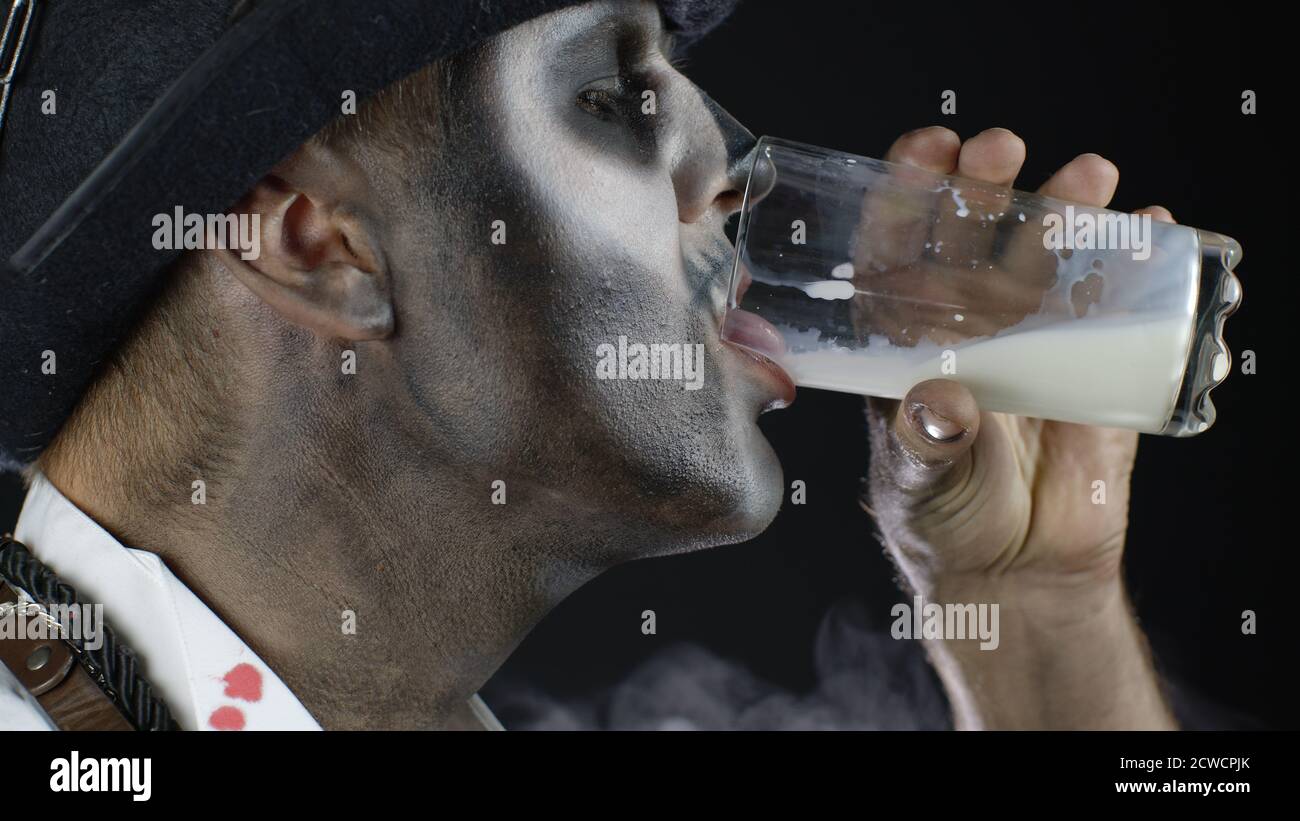 Side view of creepy man with skeleton makeup in white shirt with blood ...