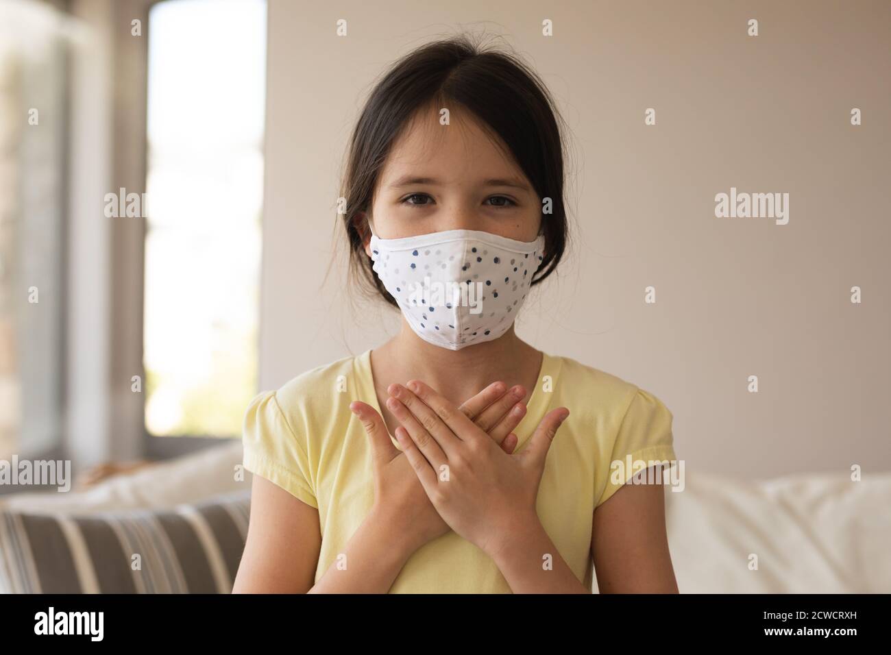 Portrait of Caucasian girl spending time at home, wearing face mask ...
