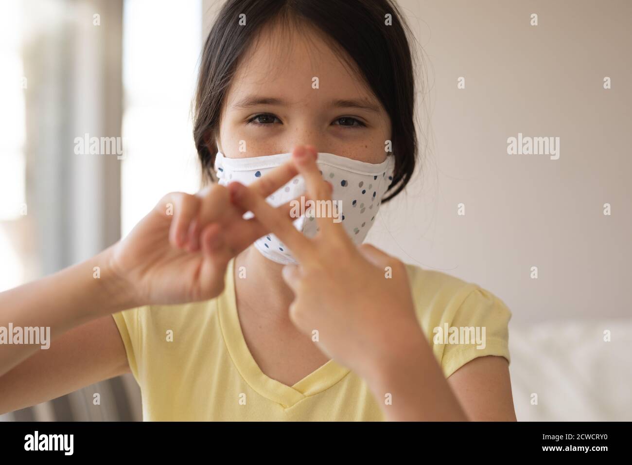 Portrait of Caucasian girl spending time at home, wearing face mask ...