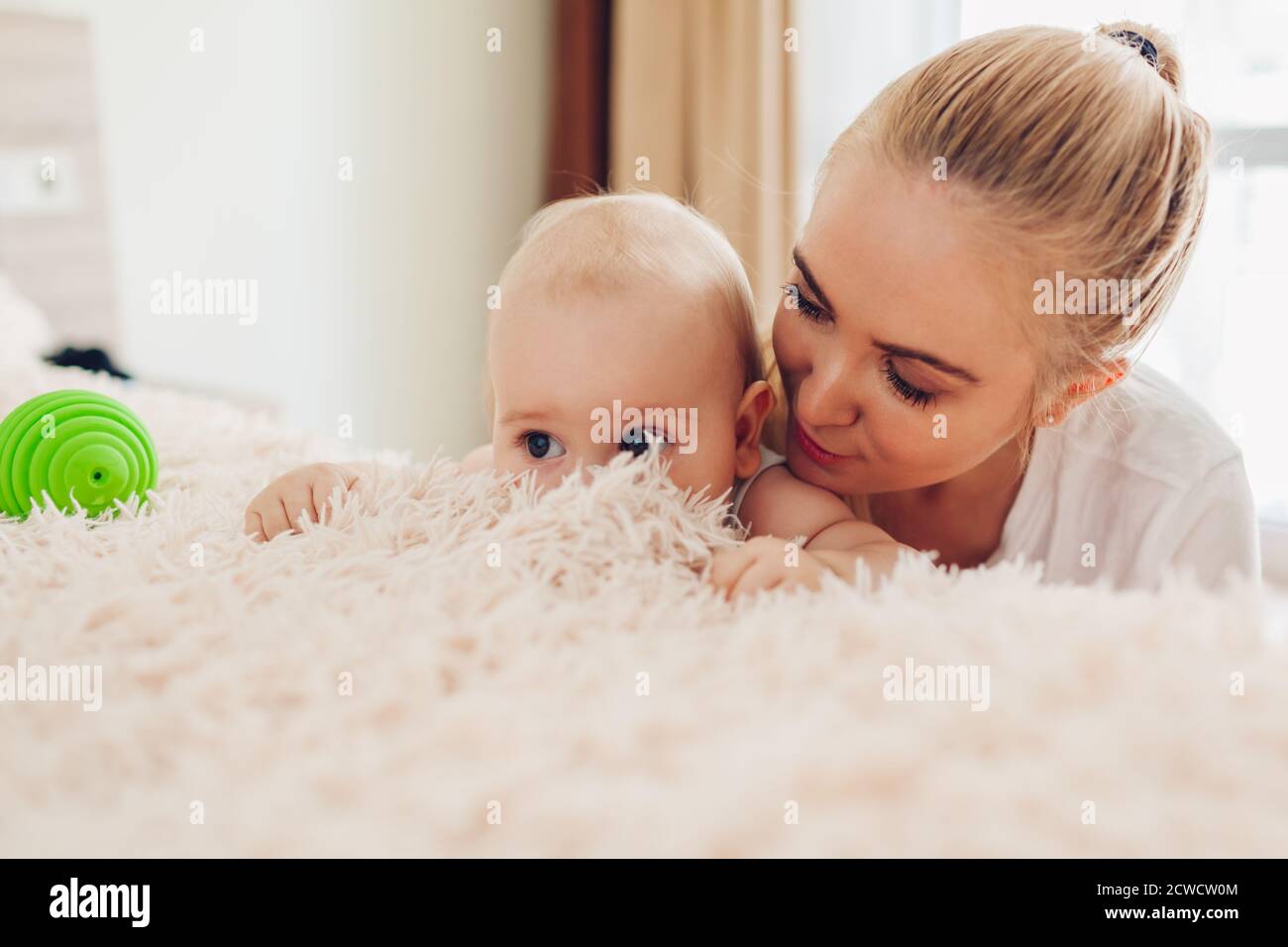 Mother playing with her newborn baby son at home. Family having fun ...