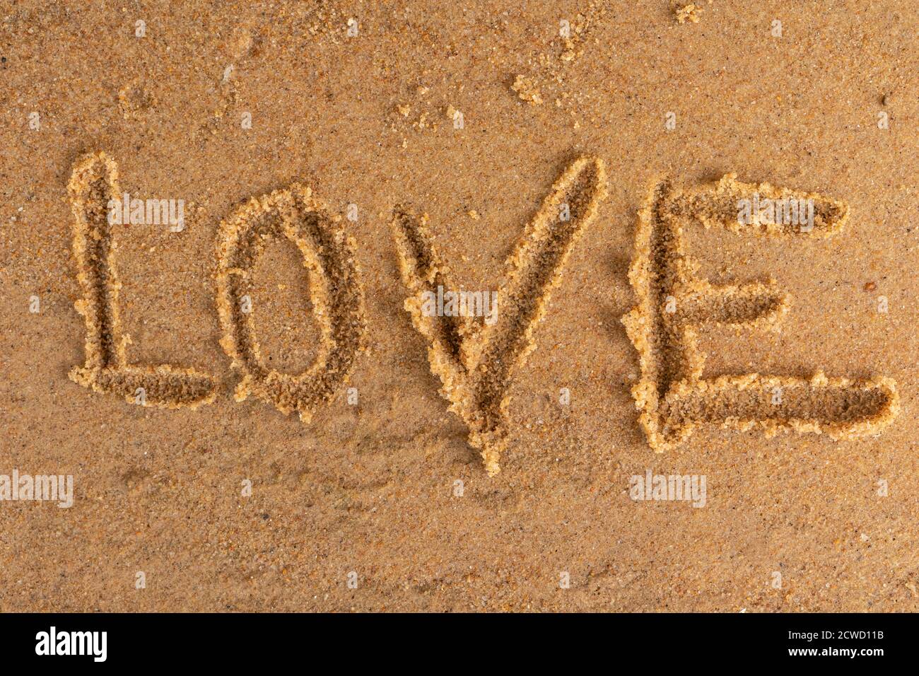 The word love in the sand background and texture. Beautiful someone ...