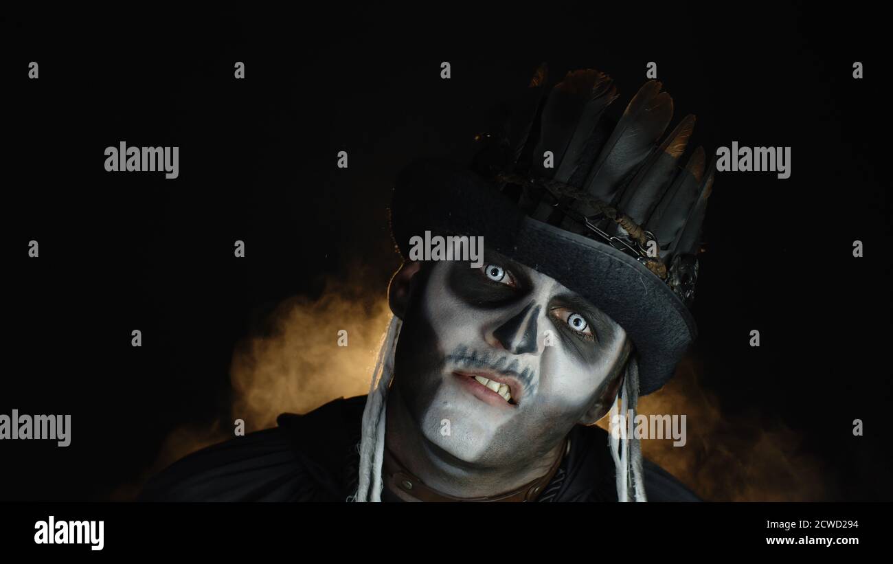 Creepy, crazy man with skeleton makeup in top-hat. Guy making angry ...
