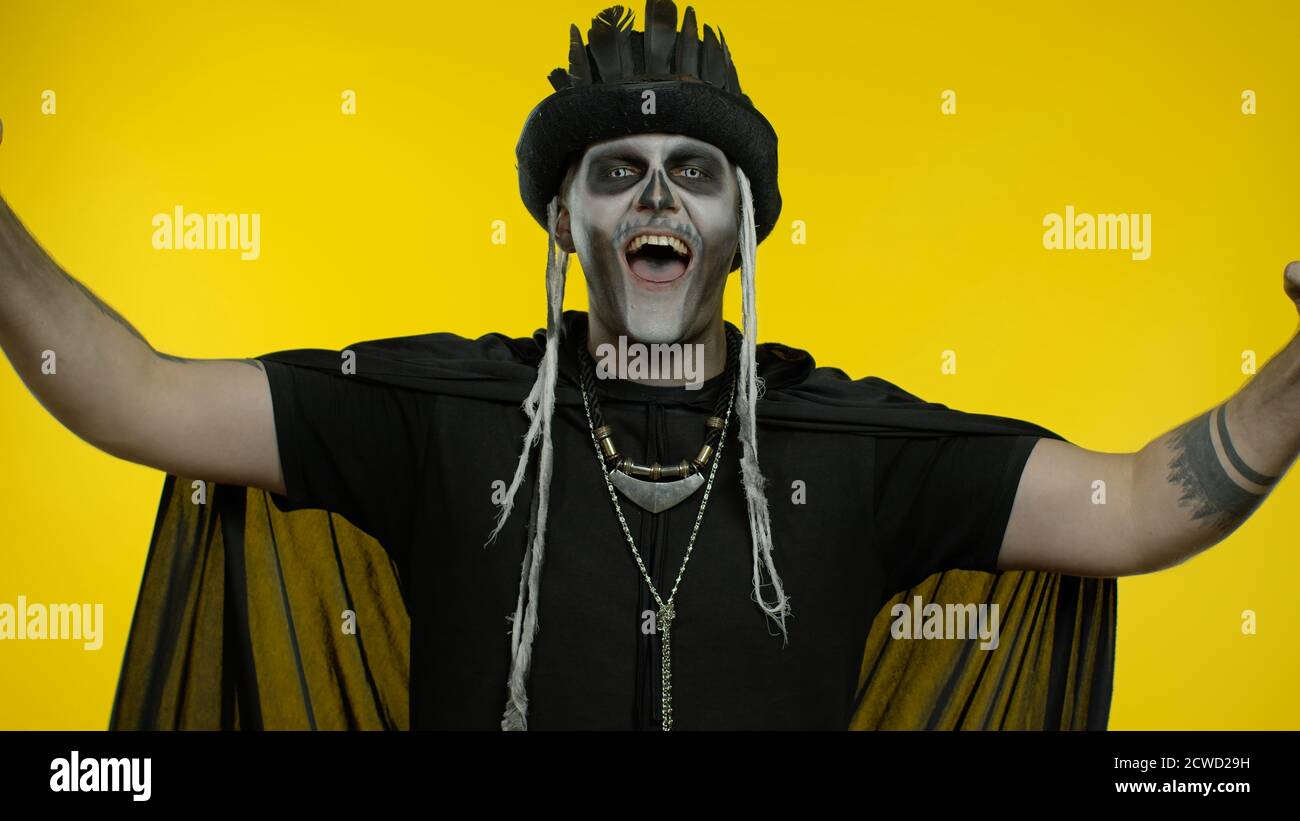 Creepy man with skeleton makeup in top-hat. Happy guy celebrating win ...
