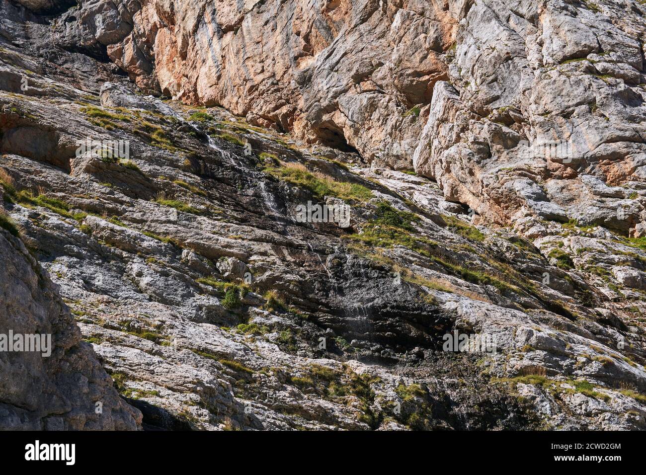 bed of an almost dry waterfall on a steep cliff in the mountains with a ...