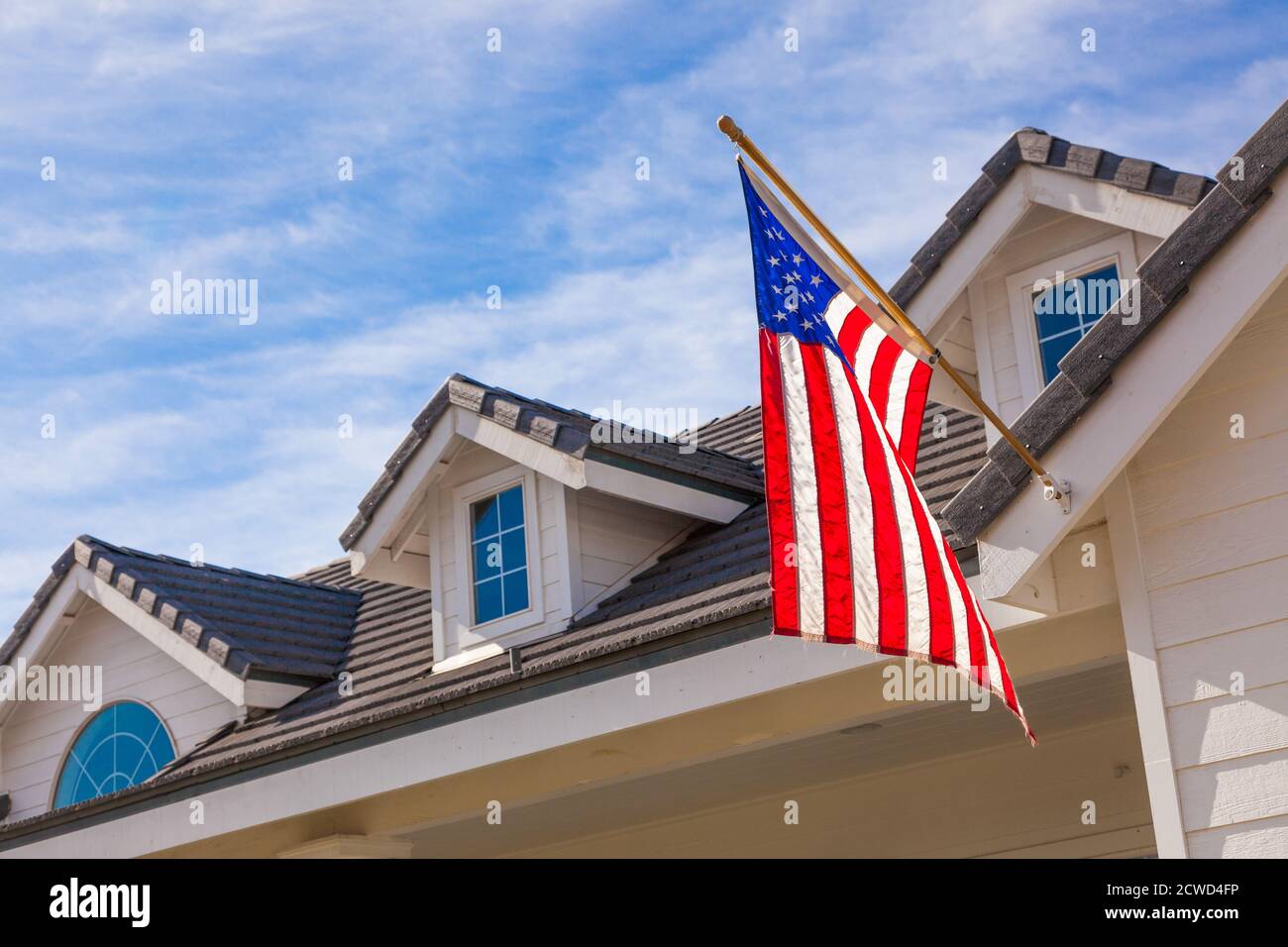American Flag Hanging From House Facade Stock Photo - Alamy