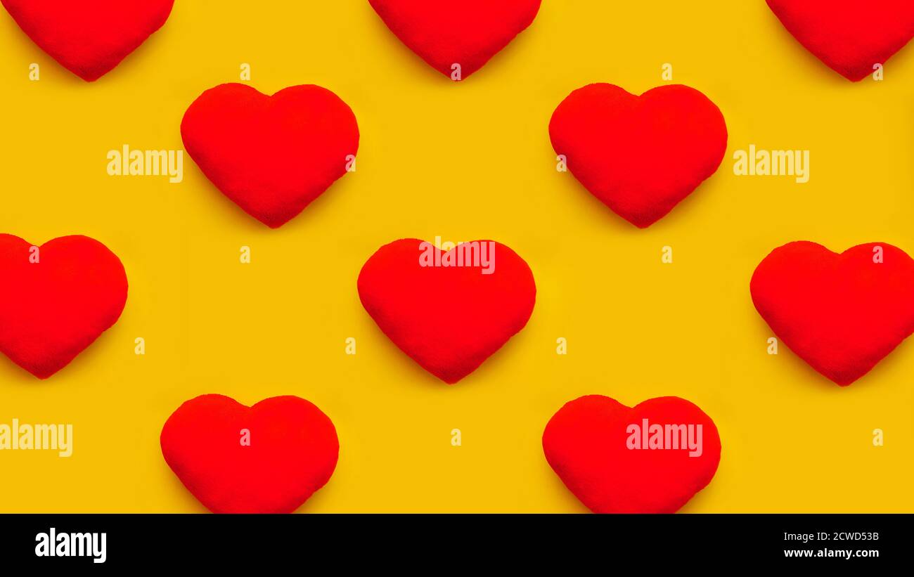 Rows of red heart toys on yellow background. Top view. Flat lay Stock ...