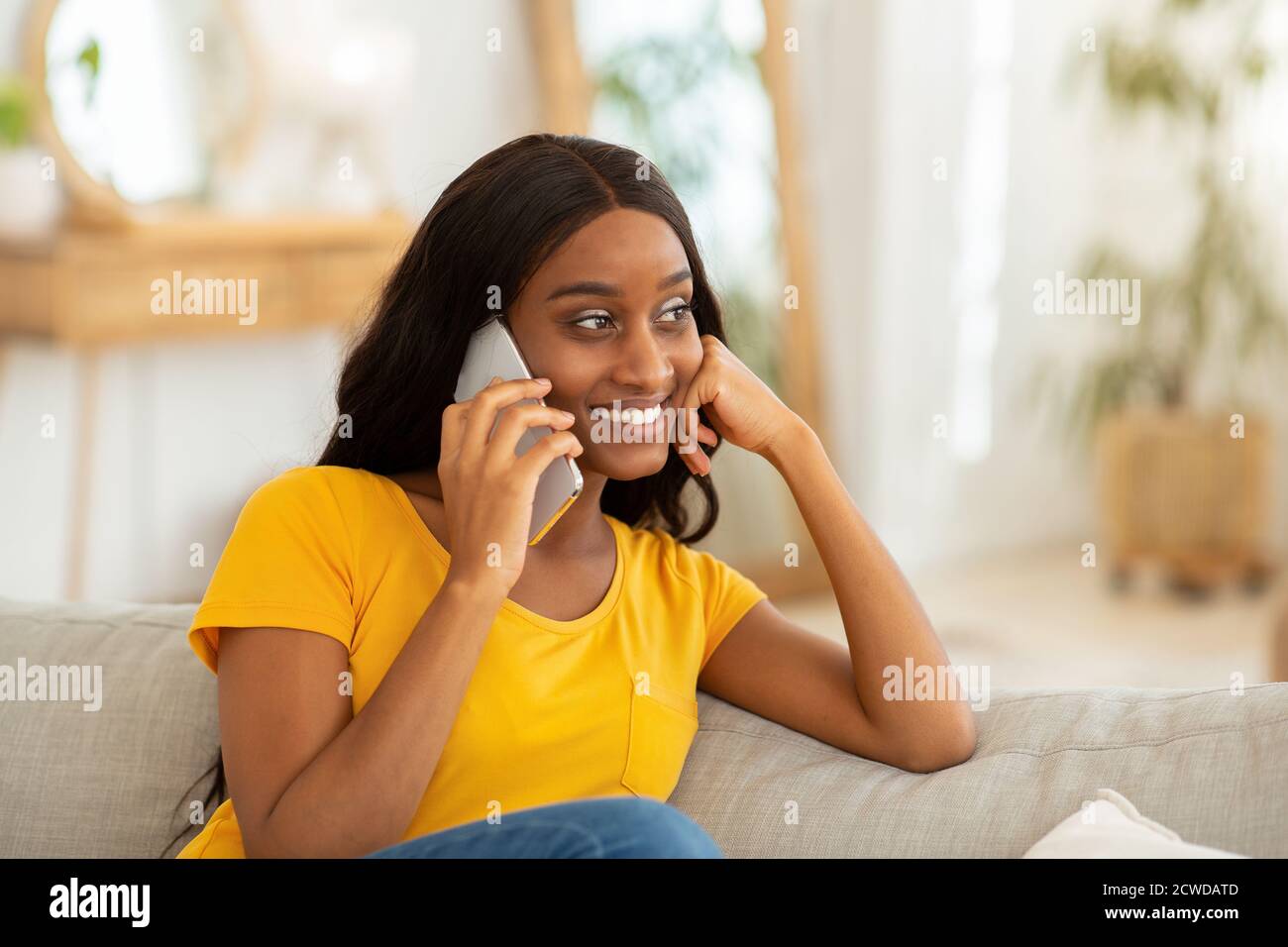 Beautiful smiling African American woman making phone call indoors ...