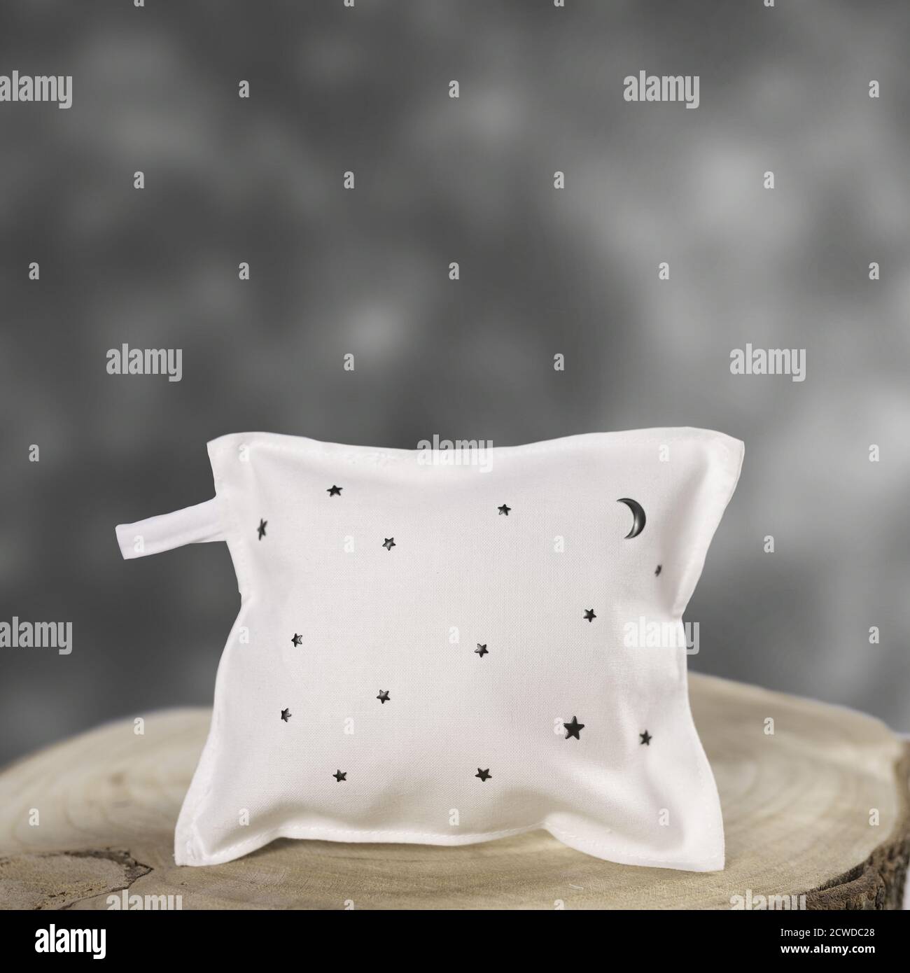 White hygiene pouch with moon and stars design, displayed on a wooden ...