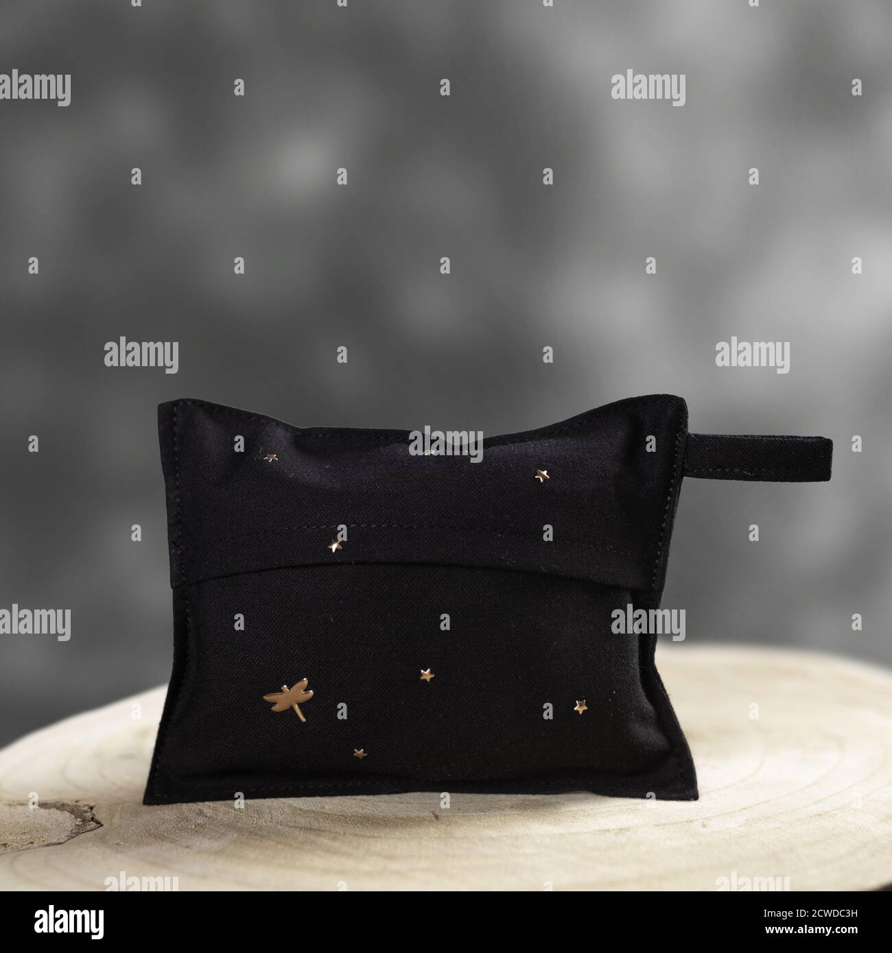 Black hygiene pouch dotted with stars, displayed on a wooden disc Stock ...