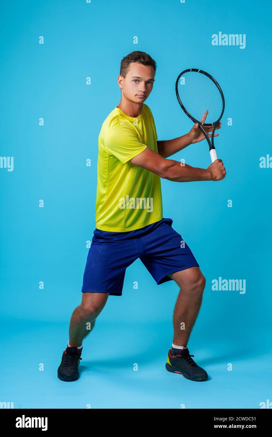 Full length studio portrait of a tennis player man on blue background ...